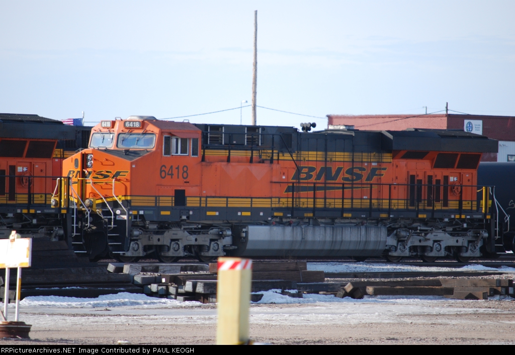 BNSF 6418 with crew door open waits to roll as a second unit behind BNSF 6424.